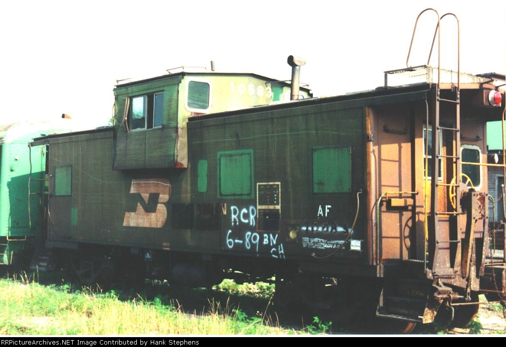 Former BN cabooue sits behind various passenger and vintage equipment at the Three Notch RR ...
